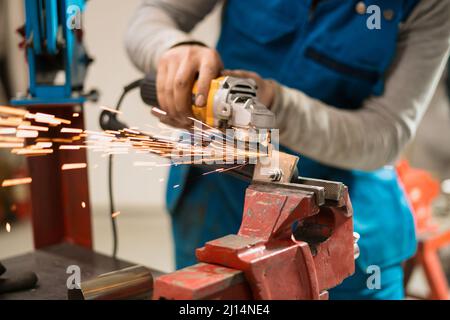 Technician worker cutting metal with many sharp sparks. Using ...
