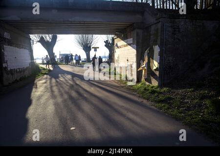 Passageway under a bridge with people strolling on a sunny day Stock ...