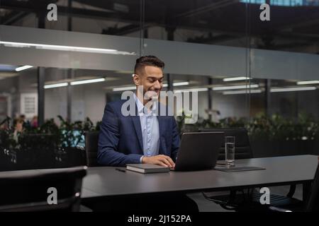 Positive arabic manager working on laptop at modern office Stock Photo ...