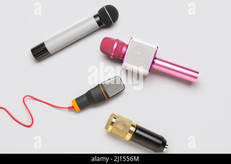 Different modern microphones on light background Stock Photo - Alamy