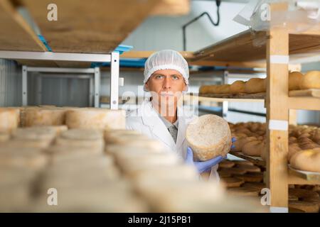 Cheesemaker checking aging process of cheese in maturing chamber Stock ...