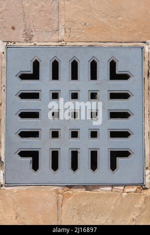 Close up image of a weathered manhole, showing its symmetrical pattern ...