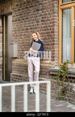 Happy freelancer standing with laptop in garden Stock Photo - Alamy