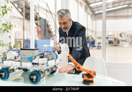 Businessman at coffee machine in car dealership Stock Photo - Alamy