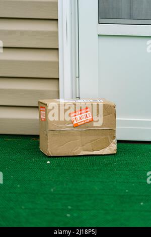 A package outside a residential door with a fragile, handle with care ...