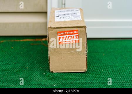 A package outside a residential door with a fragile, handle with care ...