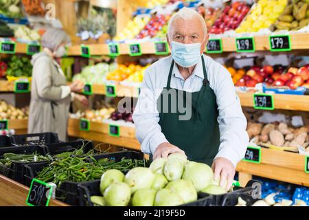 Senior man greengrocer worker setting out goods Stock Photo - Alamy