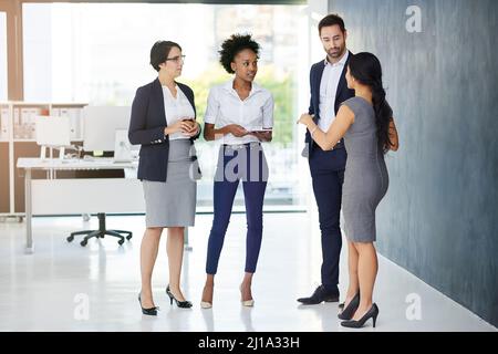 Informal discussions. Full length shot of a group of young business ...