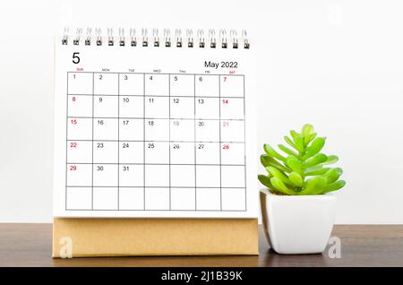 The May 2022 desk calendar with plant on wooden table Stock Photo - Alamy