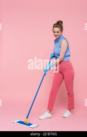 Beautiful woman with mop on pink background Stock Photo - Alamy