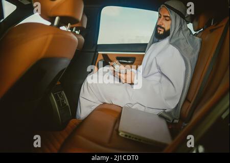 Saudi arab man holding car keys and smiling isolated on white ...