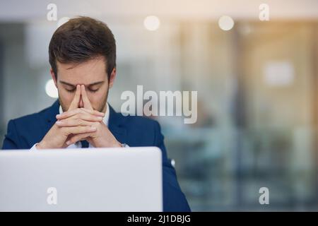 Feeling a little bit of pressure. a young man looking stressed while ...