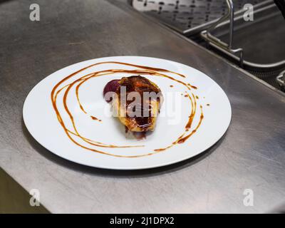 chef plating a main course with chiken and vegetables on a restaurant ...