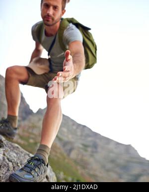 portrait of a handsome young man offering a handshake while smiling at ...