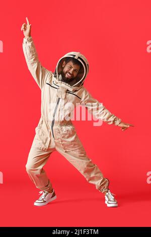Dancing beekeeper on red background Stock Photo - Alamy