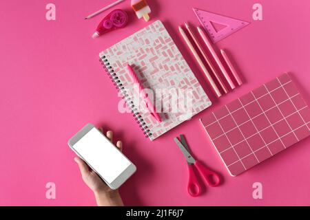Child's hand with mobile phone and stationery on grey background Stock ...