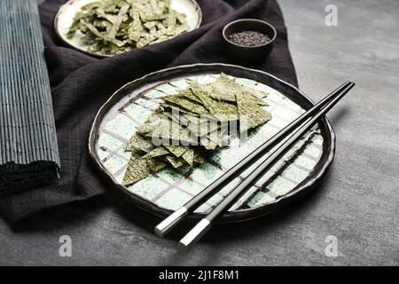 Plates of tasty seaweed sheets on black background Stock Photo - Alamy