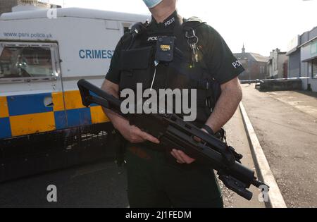 Armed PSNI police officer holds a Heckler & Koch G36C automatic machine ...