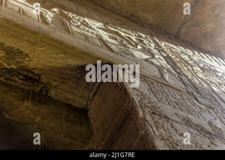 Bas relief carvings in a shaft of sunlight in the Temple of Isis at ...