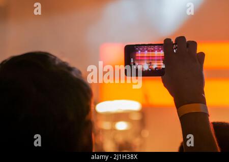 Man hands silhouette recording video of live music concert with ...