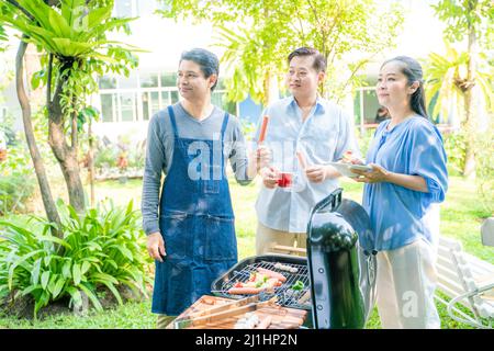 Happy seniors food meeting BBQ grilled party style in the garden Stock ...