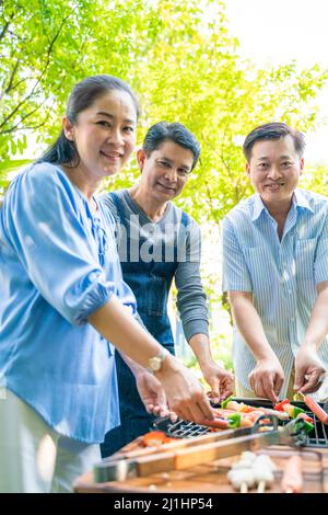 Happy seniors food meeting BBQ grilled party style in the garden Stock ...