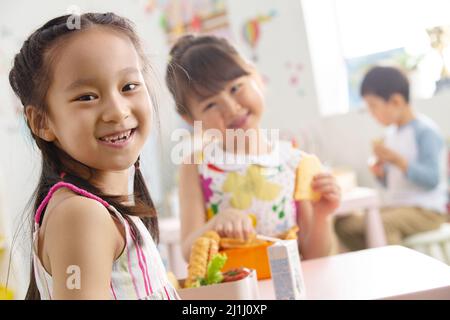 Kindergarten children eat Stock Photo - Alamy