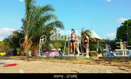 A distant view of two females working out at the beach in Koh Samui ...