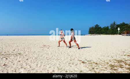 A distant view of two females working out at the beach in Koh Samui ...
