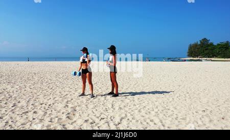 A distant view of two females working out at the beach in Koh Samui ...