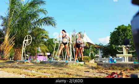 A distant view of two females working out at the beach in Koh Samui ...