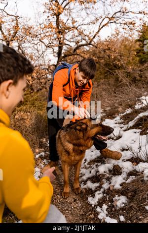 Amazing and handsome male friends are brushing the dog with his brush ...