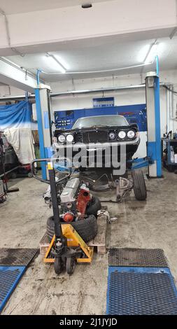 Car workshop, black classic car on a lifting platform Stock Photo - Alamy