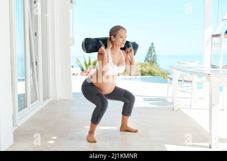 Lifting her way to a strong pregnancy. Shot of a pregnant woman working ...