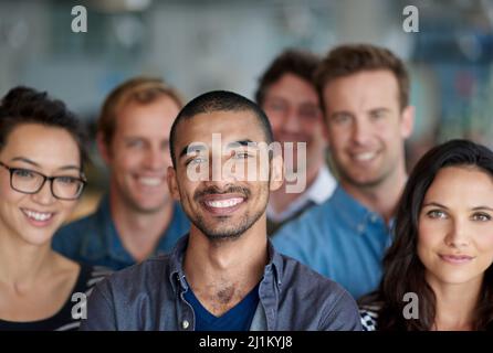 Standing proud. a smiling group of coworkers standing in an office ...