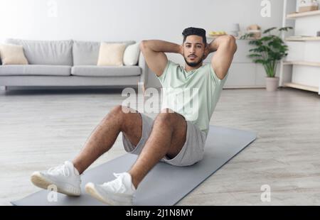 Young arab man training abs exercise at sport center Stock Photo - Alamy