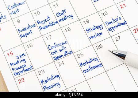 Handwriting scheduling appointments on calendar sheet with pen Stock ...