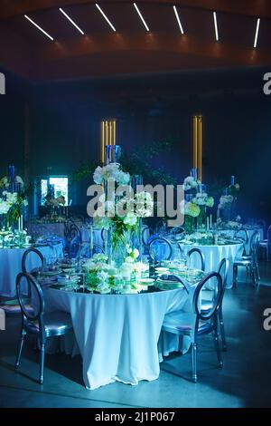 Table setup in blue light. Ready to event Stock Photo - Alamy