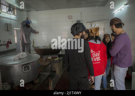 A group of locals and tourists at the free kitchen (Langar) of the ...