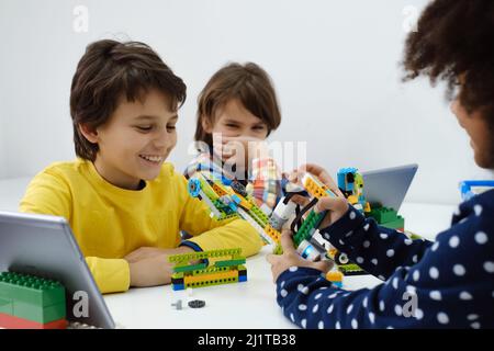 Coding Class, school girl constructing robot arm mechanism. multiethnic ...