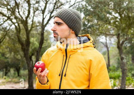 Serious bearded guy in outerwear browsing smartphone while chatting on ...