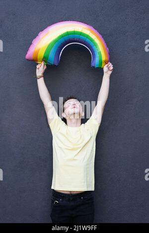 Side view of aged female artists in protective mask painting on canvas in backyard on sunny day ...