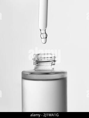 liquid dripping from pipette into flask isolated Stock Photo - Alamy