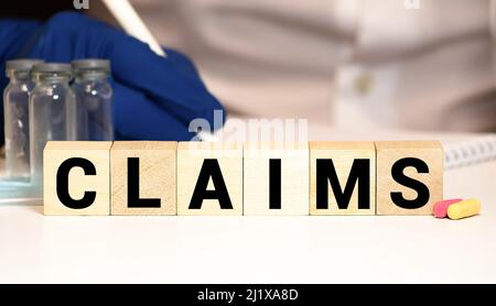 claims word written on wood block. claims text on wooden table for your ...