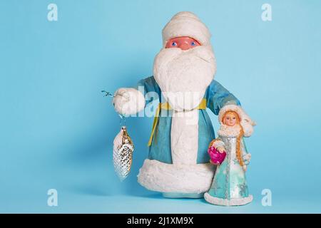 Toy Russian Ded Moroz holds Christmas tree toy Santa Claus in his hand ...