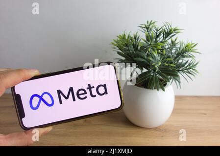 Facebook logo is displayed on a mobile phone screen photographed for ...