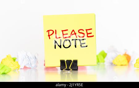 Please Note Sign on white paper. Man Hand Holding Paper with text ...