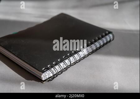 Black spring-loaded notebook against a gray background. Close-up of a ...