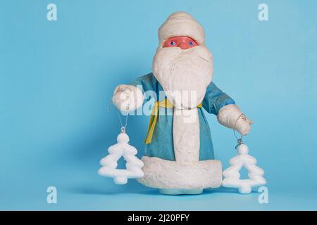 Toy Russian Ded Moroz holds Christmas tree toy Santa Claus in his hand ...