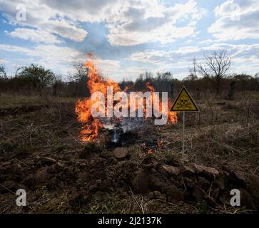 Poison toxic symbol and burning grass surrounded by smoke from fire ...